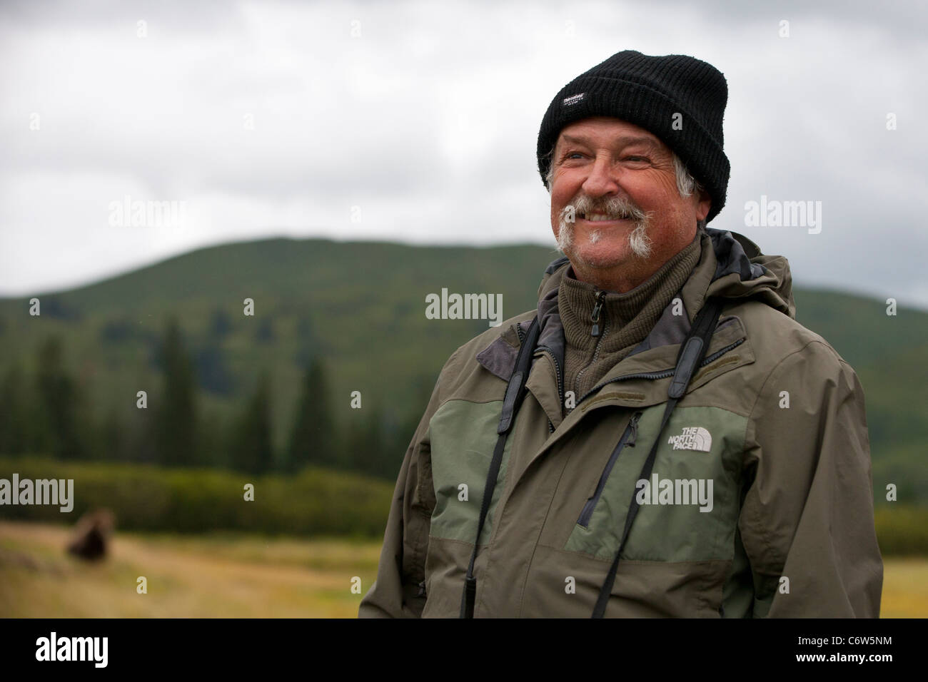 A tour guide scouts a field for North American brown bear, Lake Clark ...