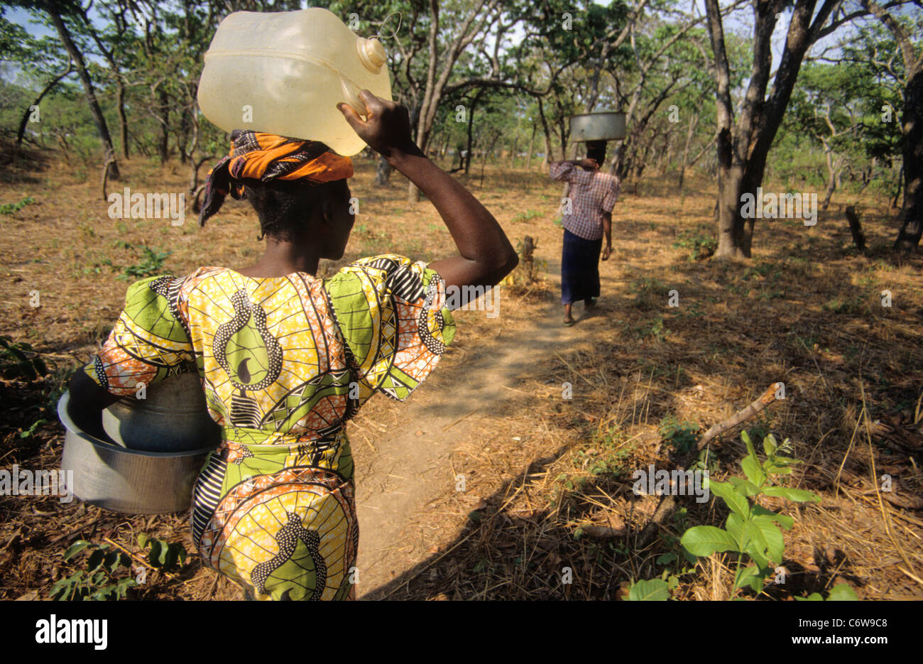 Refugee from the democratic republic of congo collects water from a ...