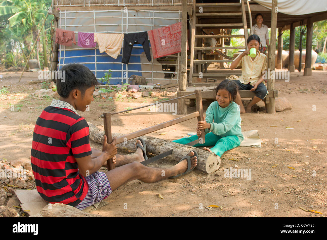 Children cutting logs with a two-handed saw, Phnom Leap Village, near ...