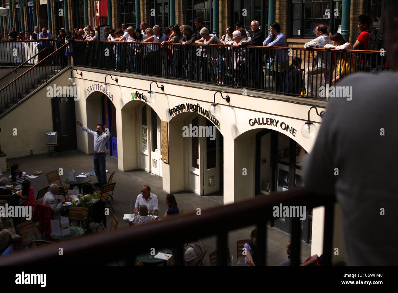 People watching an Opera singer performing (on the chair) in Covent ...