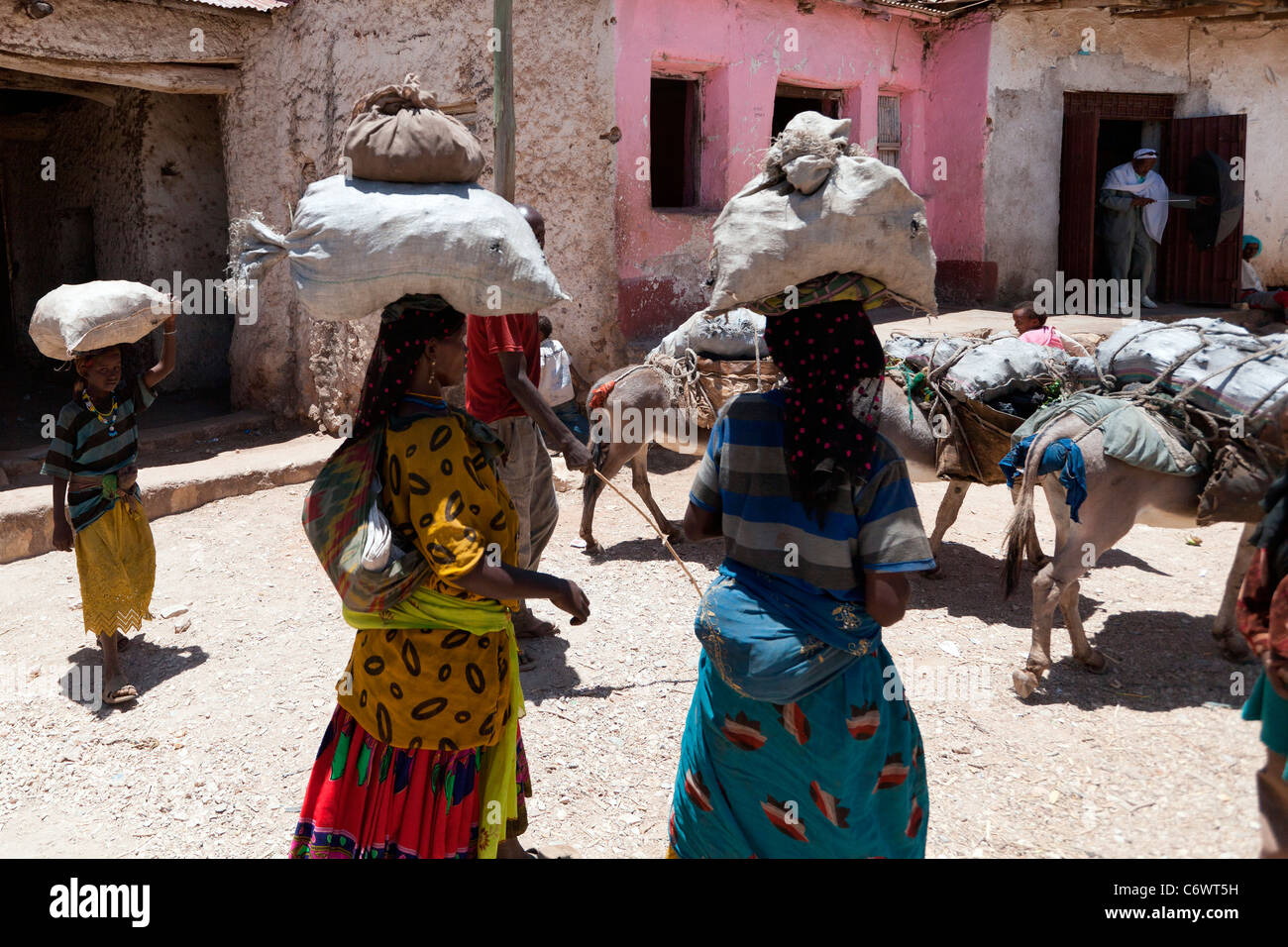 Harari women carry provisions on their heads through the streets of ...