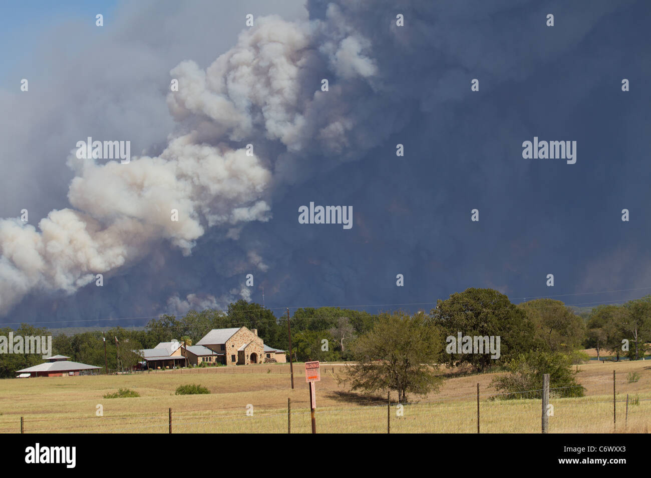Smoke clouds from the Bastrop Texas wildfire dwarfs houses in forgeound ...