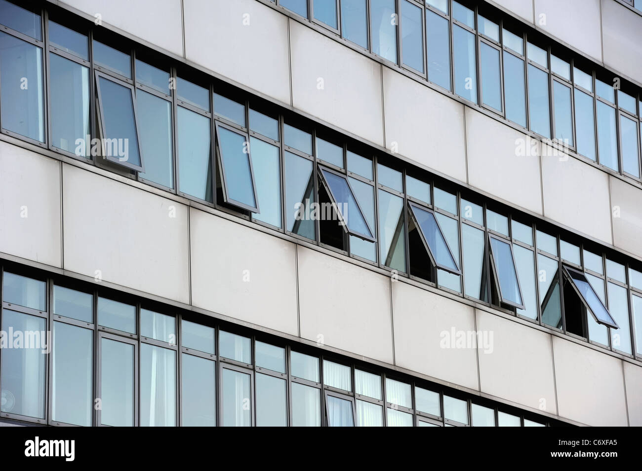 Detail of a glass-fronted office block with open windows Stock Photo ...