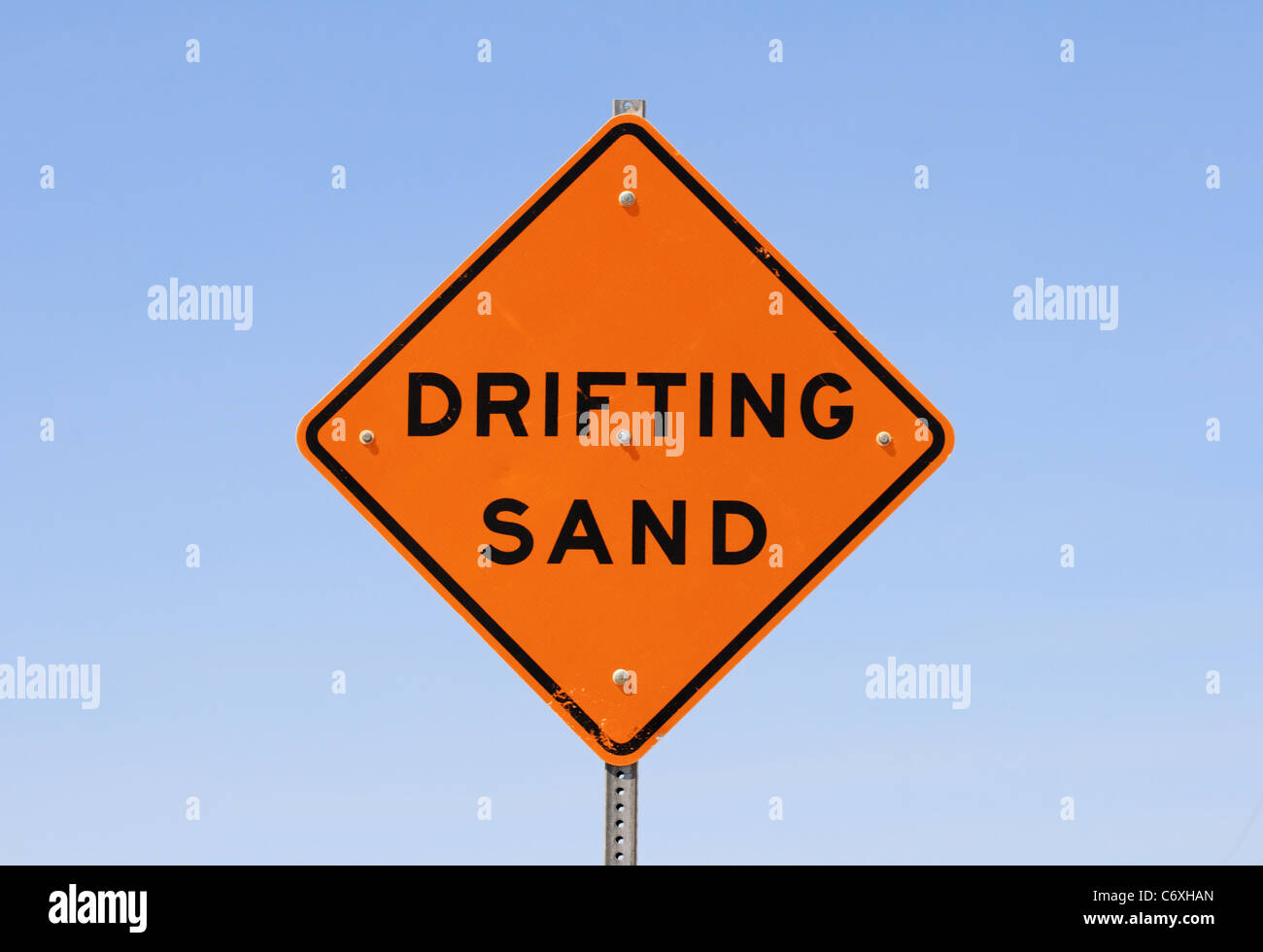 orange and black drifting sand road sign with blue sky background Stock ...