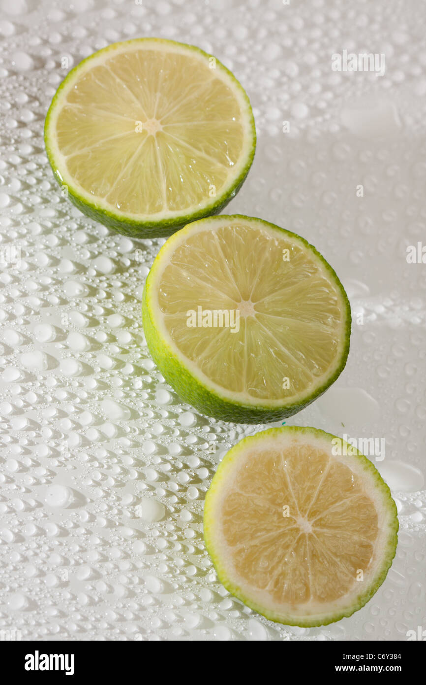 Lime with water drops on white Stock Photo - Alamy