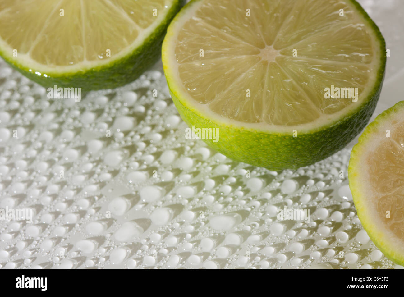 Lime with water drops on white Stock Photo - Alamy