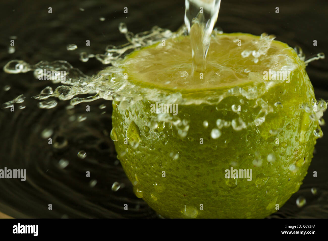 Lime with water drops with splashing Stock Photo - Alamy