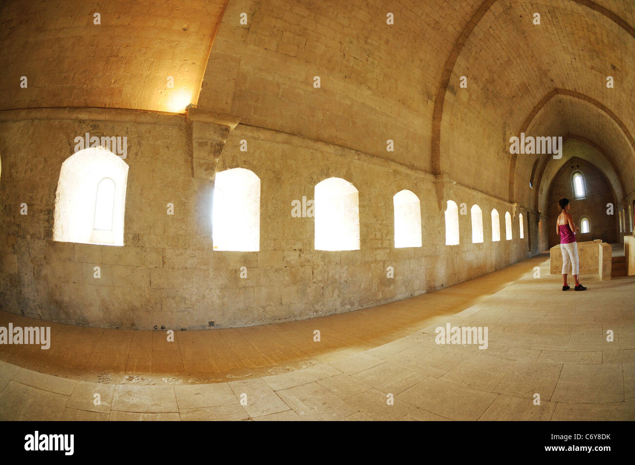 Tourist visiting monk's dormitory in former Cistercian monastery ...