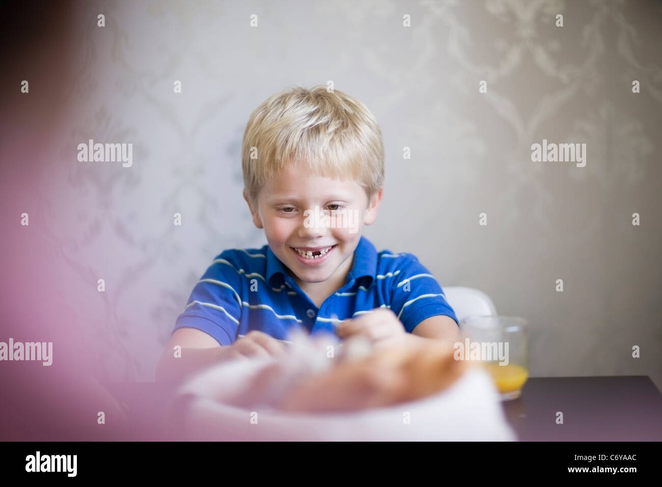 Boy smiling at dinner table Stock Photo - Alamy