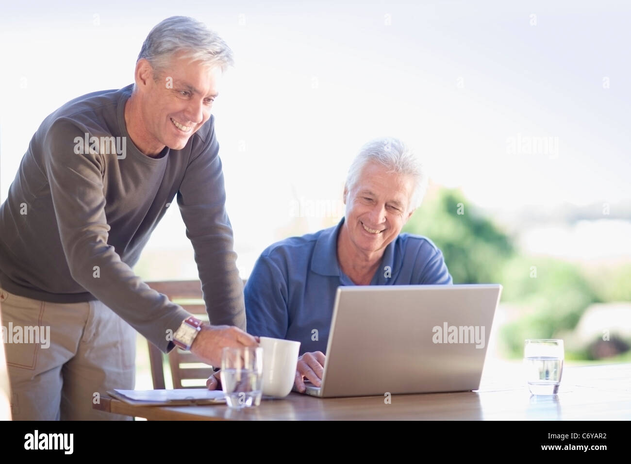 Older men using laptop together Stock Photo - Alamy