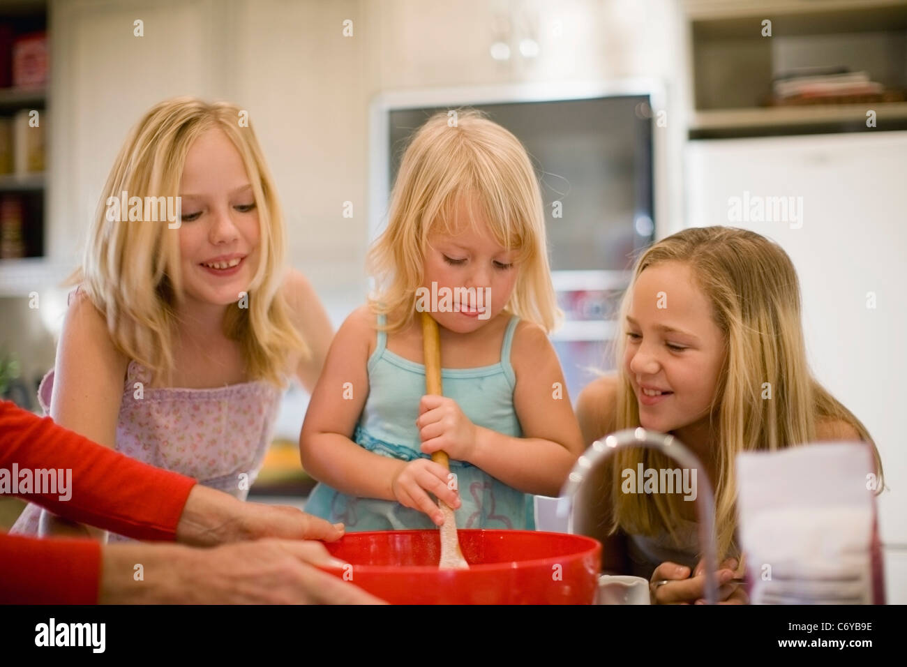 Sisters cooking together in kitchen Stock Photo - Alamy