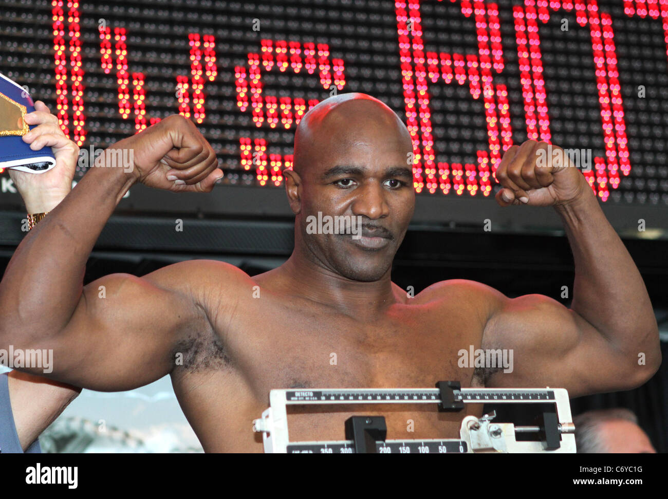 Evander Holyfield poses on the scale during the official weigh-in for ...