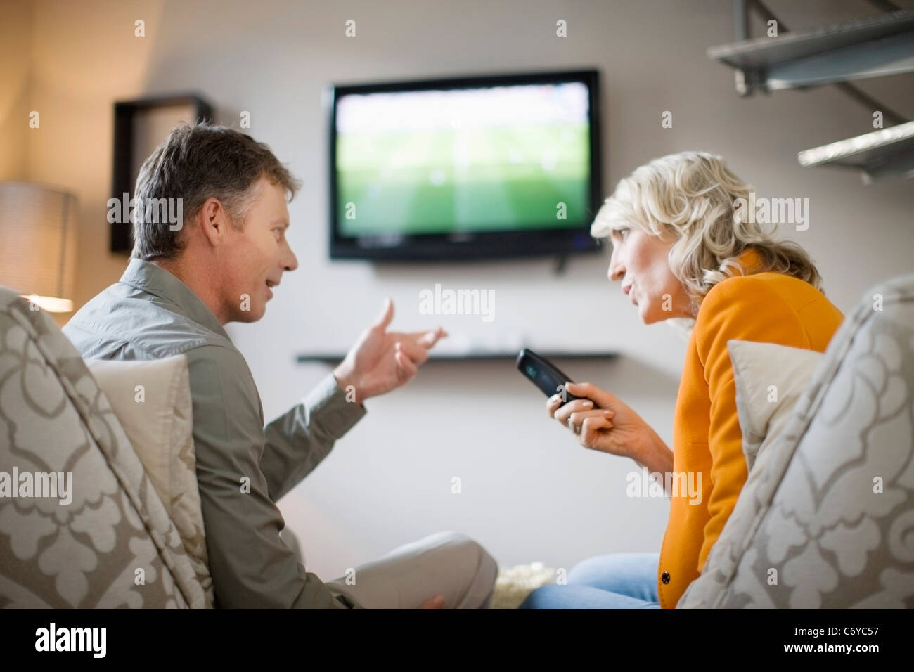 Couple arguing over remote control Stock Photo - Alamy