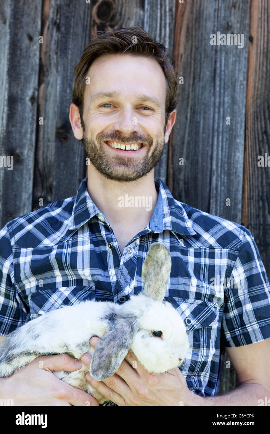 Man holding rabbit outdoors Stock Photo - Alamy