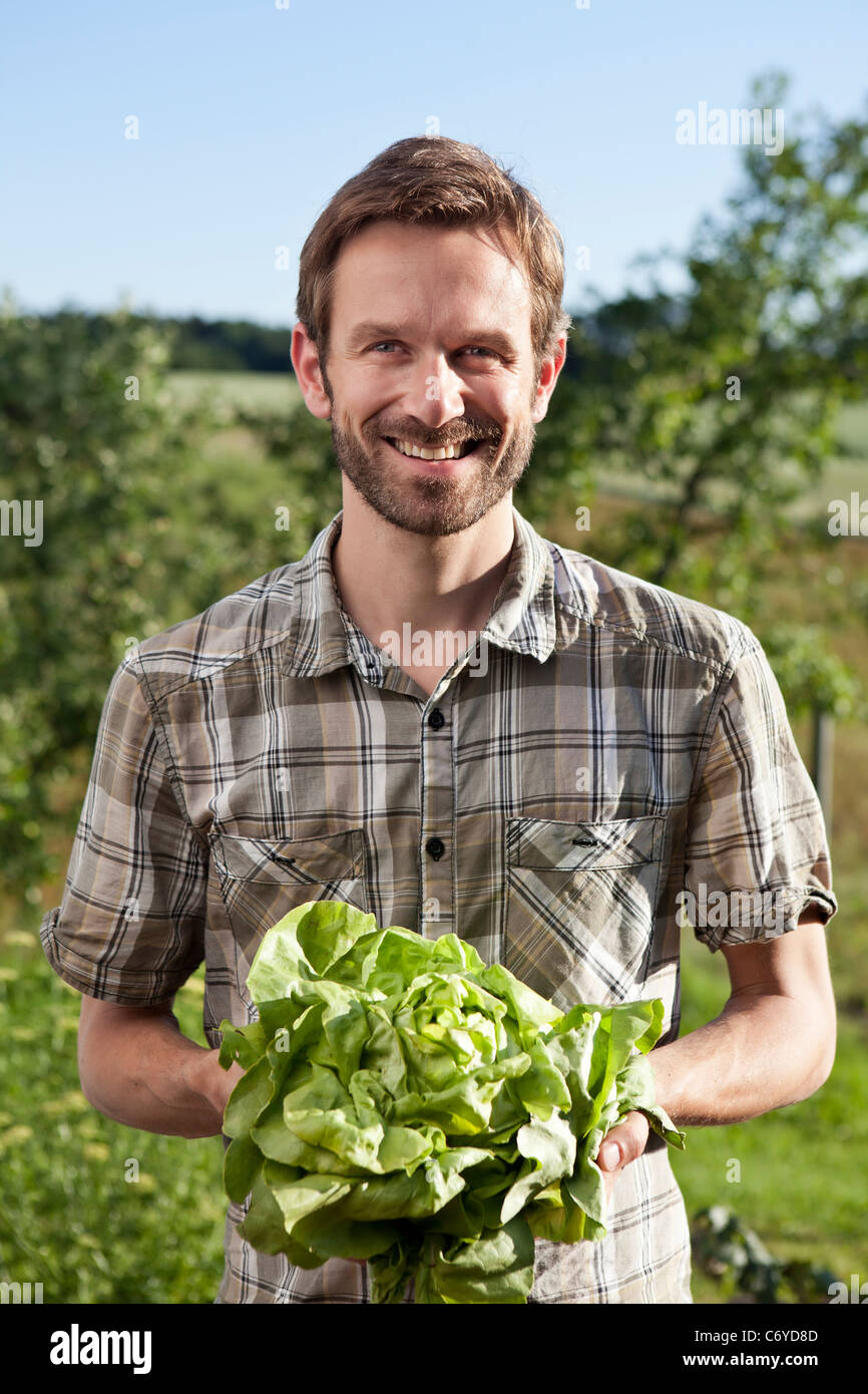 Man holding head of lettuce outdoors Stock Photo - Alamy