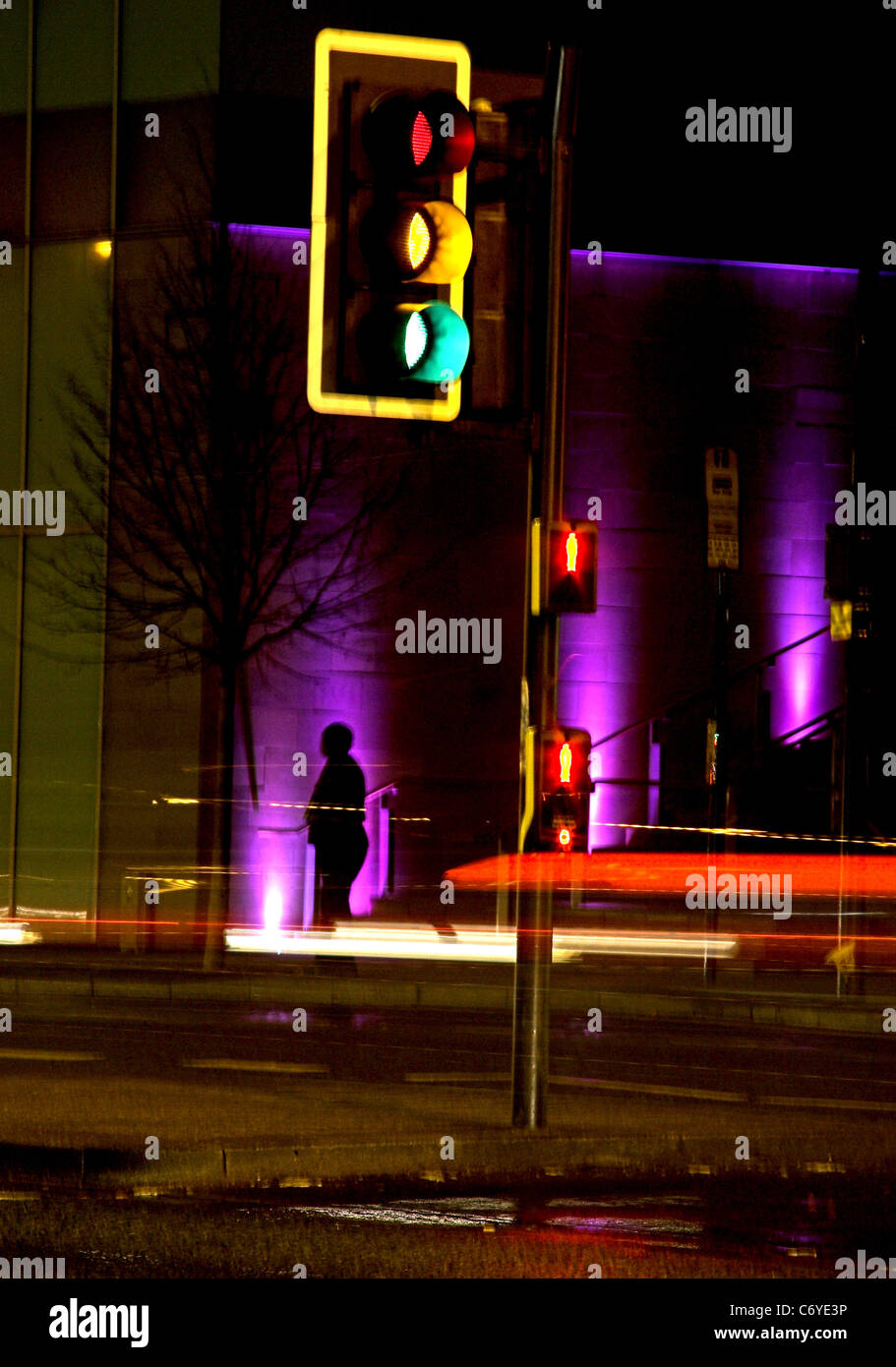 A pedestrian crossing at night in a city centre with light trails from ...