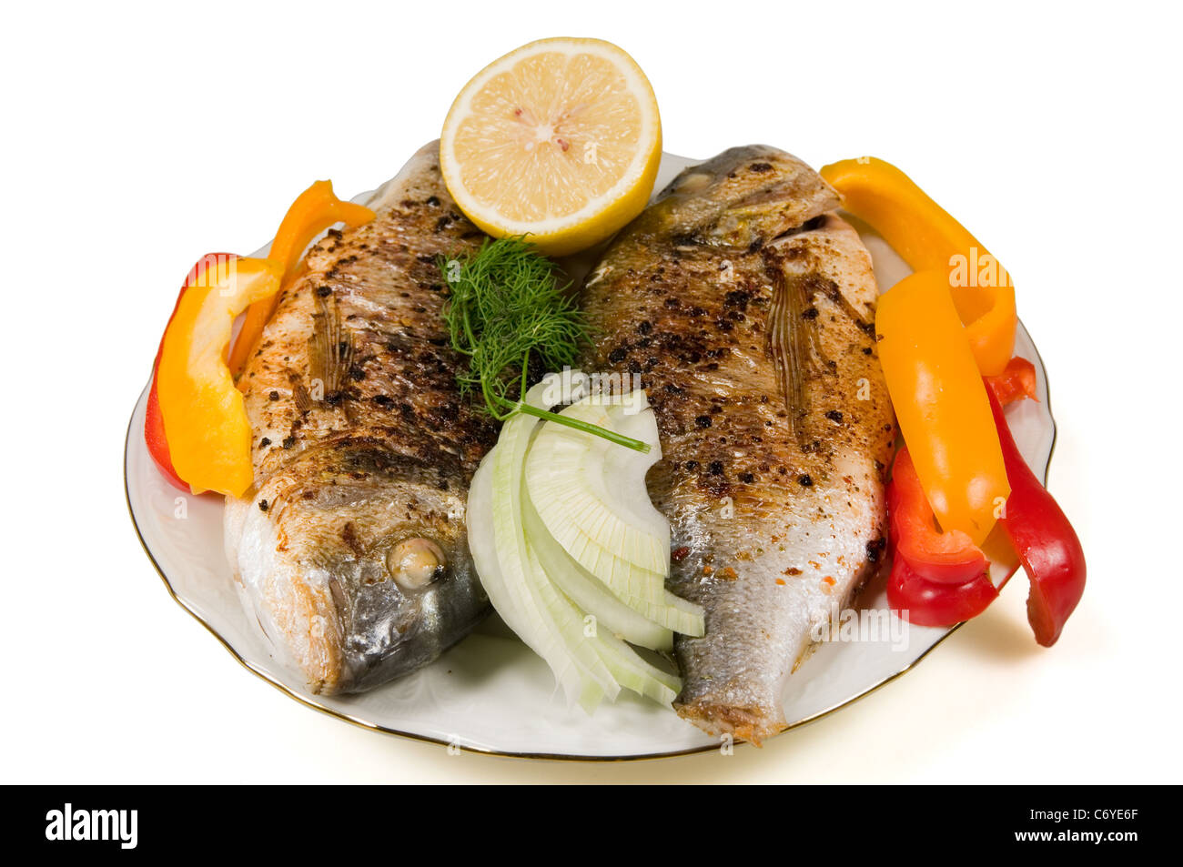 Fried fish (dorada) in a dish with vegetables and lemon Stock Photo - Alamy