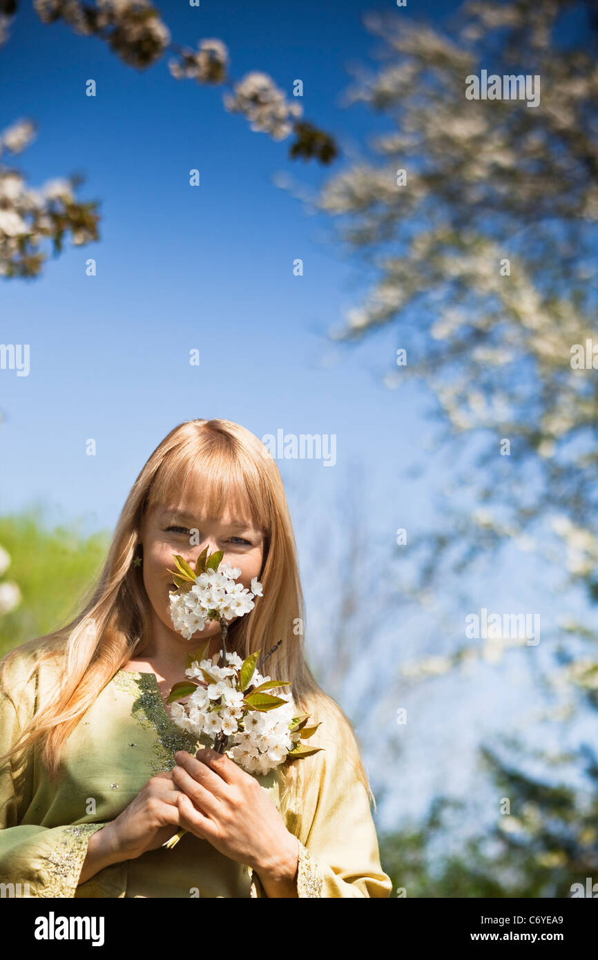Woman smelling flowers outdoors Stock Photo - Alamy