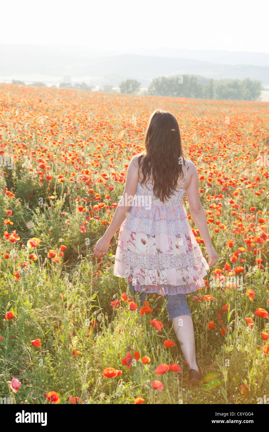 Woman walking in field of flowers Stock Photo - Alamy
