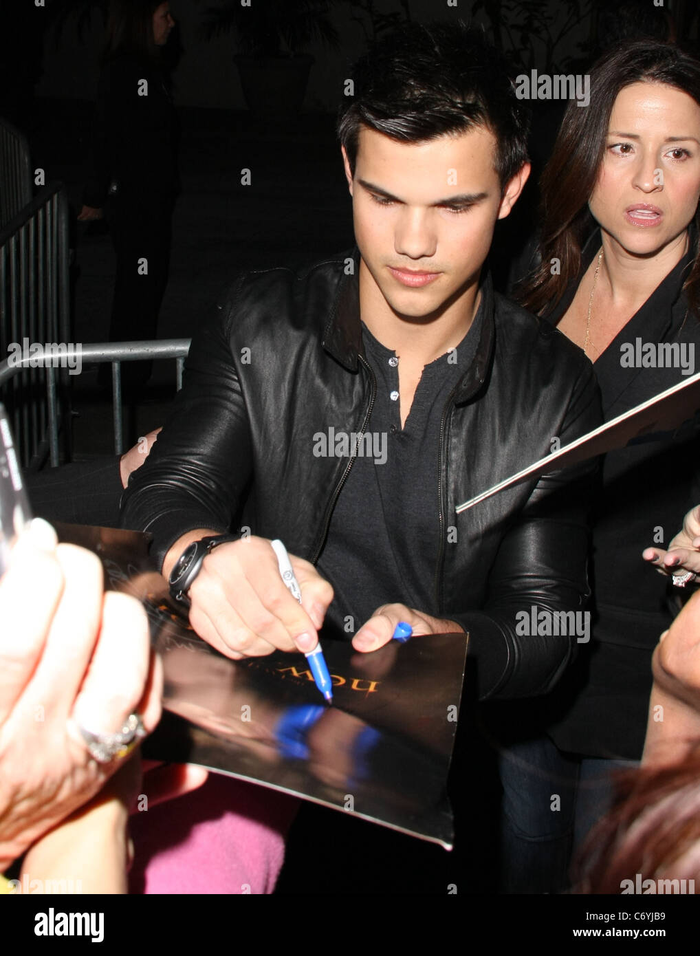 Taylor Lautner signs autographs for fans as he leaves the premiere of ...