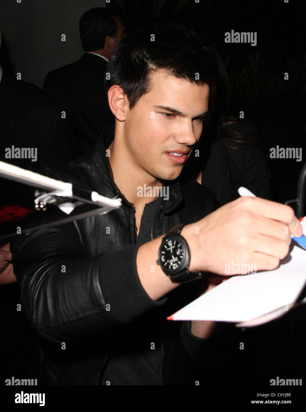 Taylor Lautner signs autographs for fans as he leaves the premiere of ...