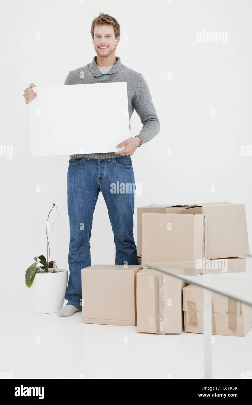 Man carrying boxes in new home Stock Photo - Alamy