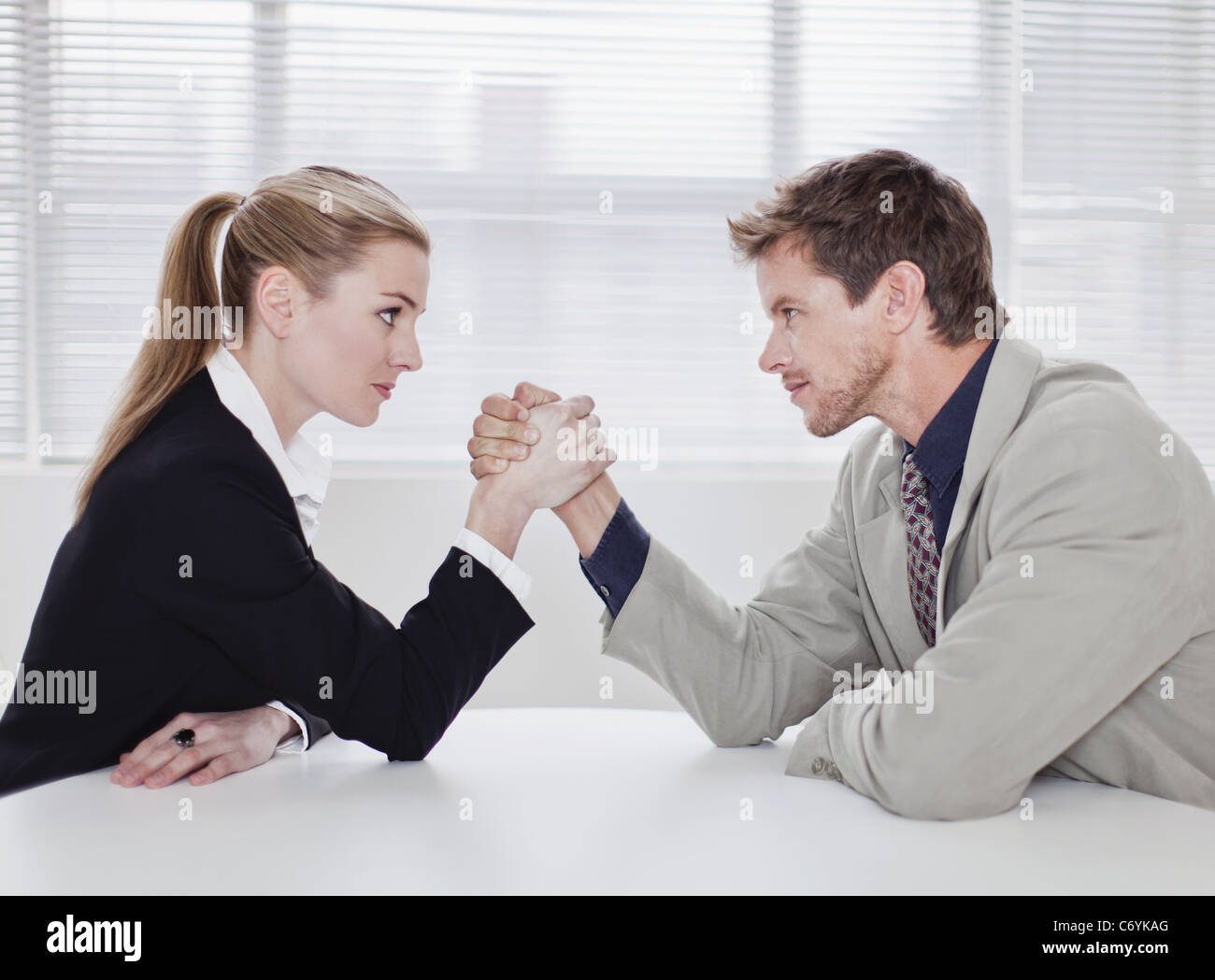 Rival business people arm wrestling Stock Photo - Alamy