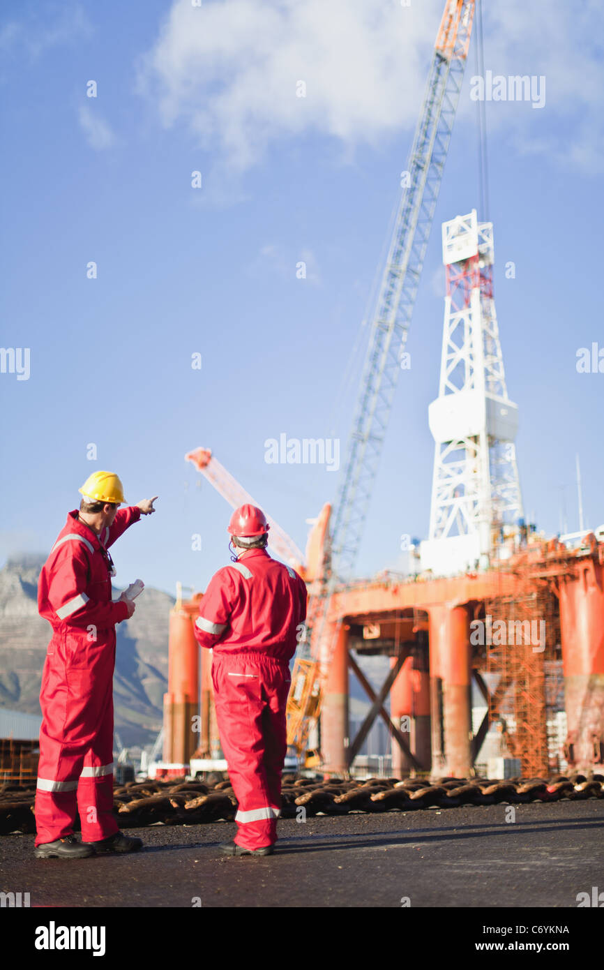 Workers talking on oil rig Stock Photo - Alamy