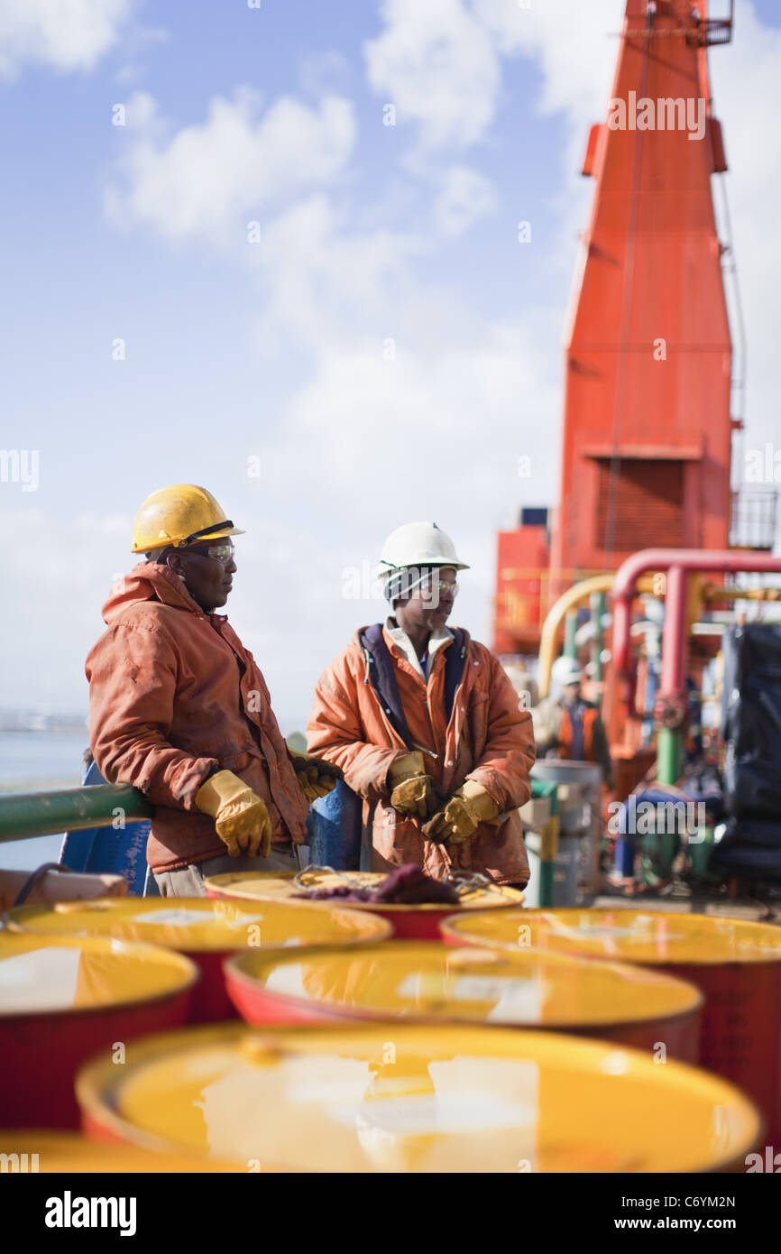 Workers standing on oil rig Stock Photo - Alamy