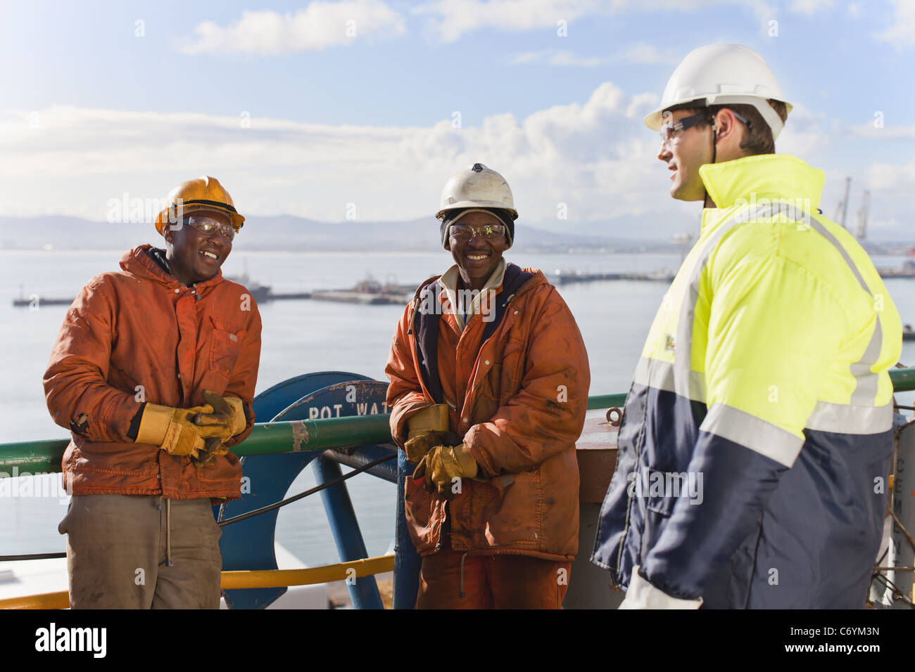 Workers talking on oil rig Stock Photo - Alamy