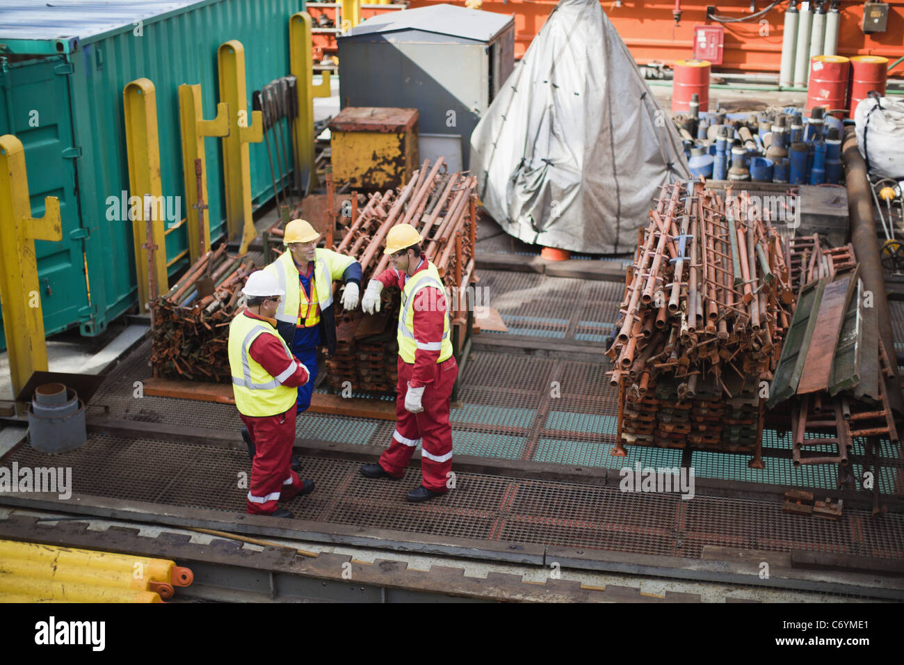 Workers talking on oil rig Stock Photo - Alamy