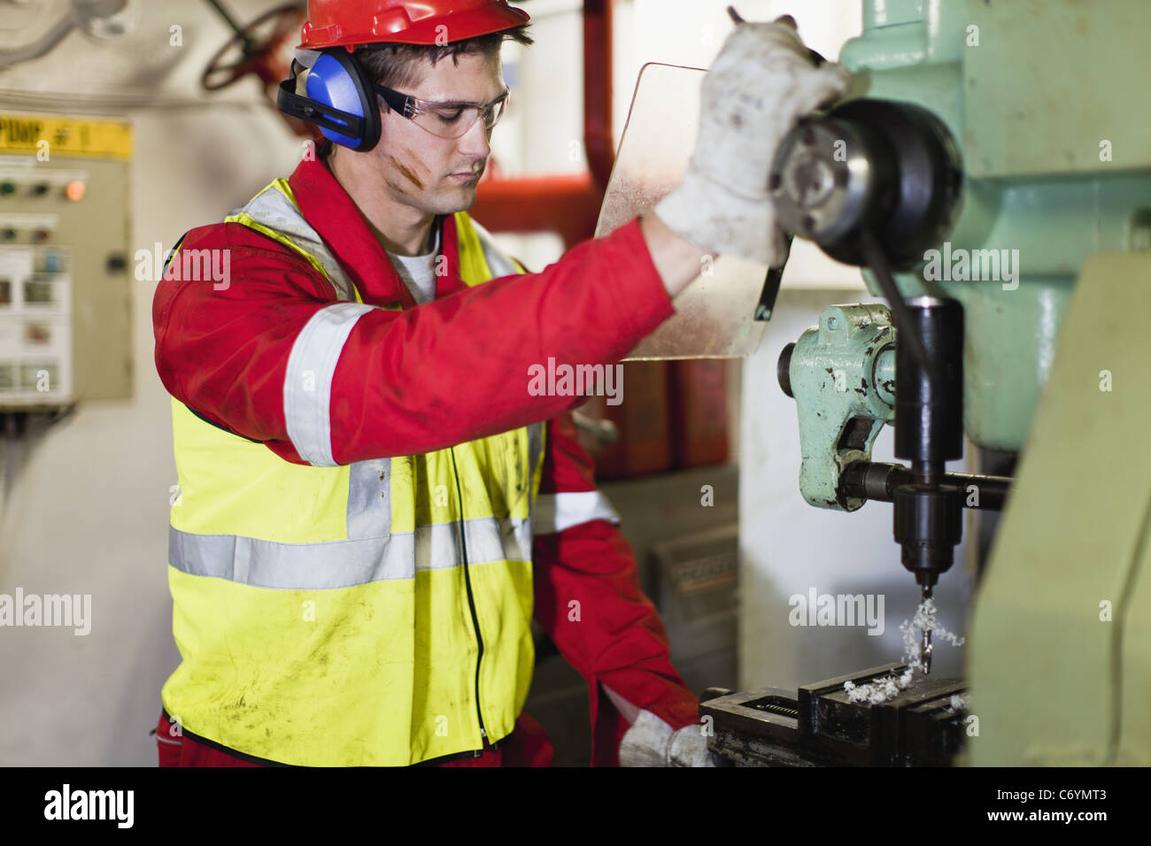 Worker using machinery on oil rig Stock Photo - Alamy