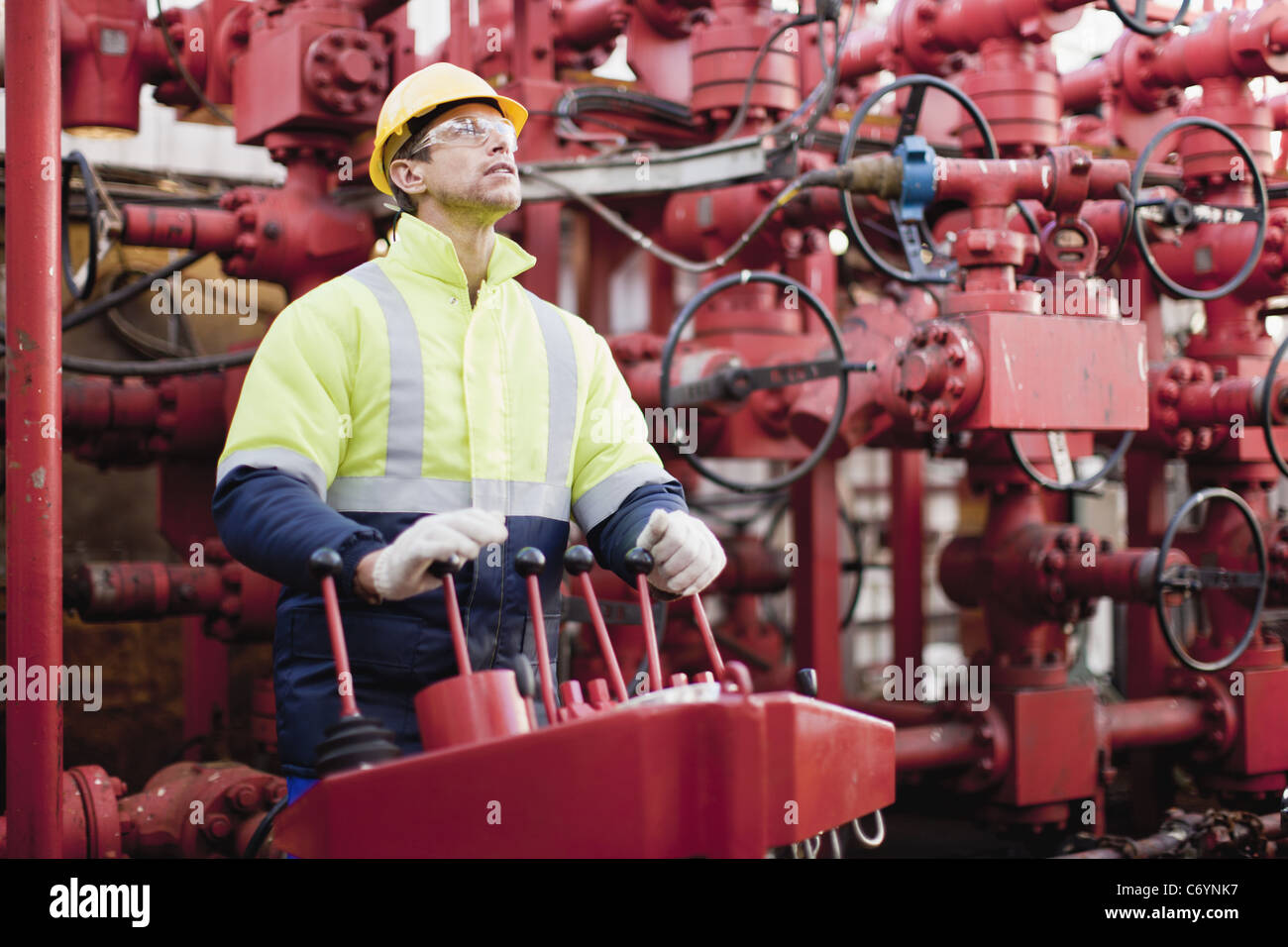 Worker operating machinery on oil rig Stock Photo - Alamy