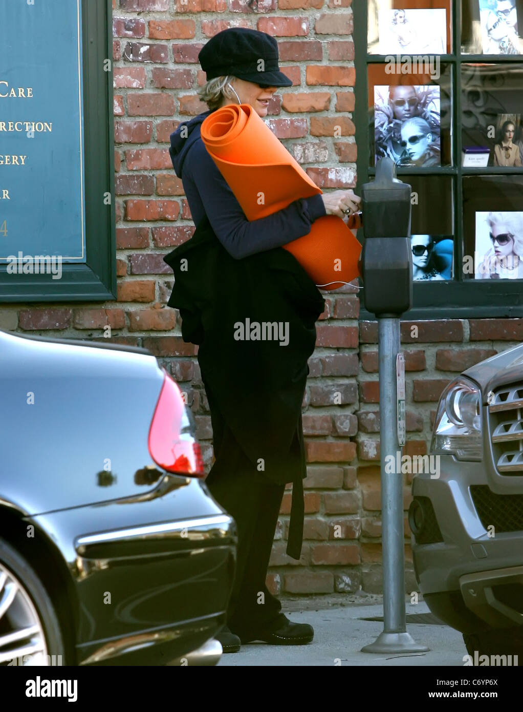 Meg Ryan carrying her orange yoga mat on her way to class in Santa ...