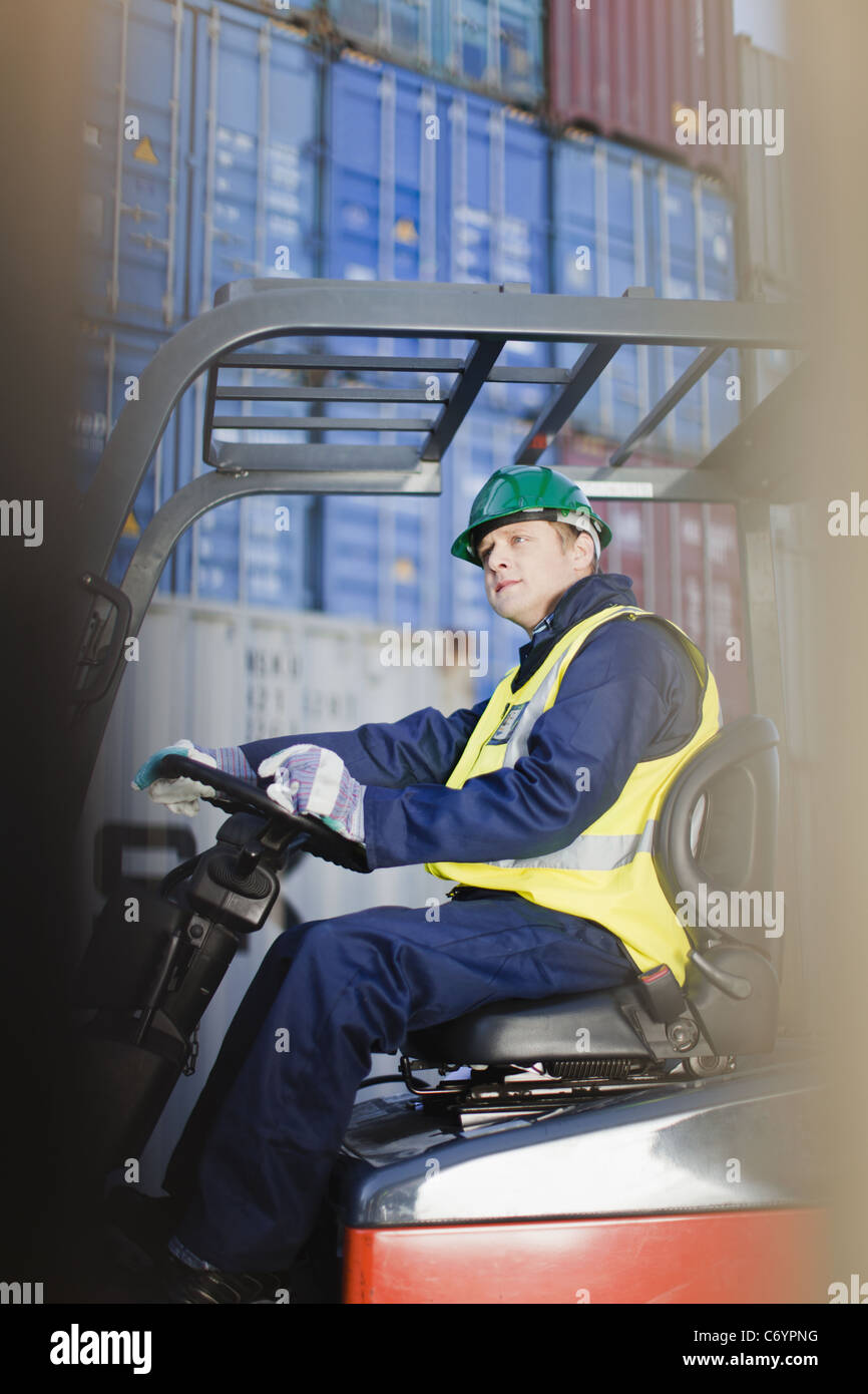 Worker using machinery in shipping yard Stock Photo - Alamy