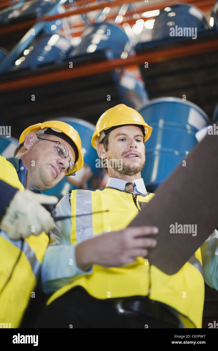 Workers reading clipboard in warehouse Stock Photo - Alamy