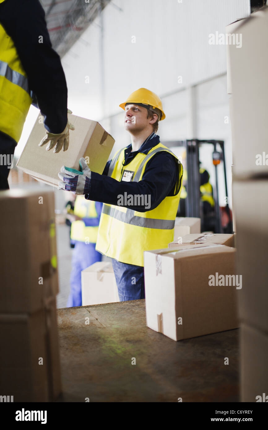 Workers unloading boxes from truck Stock Photo - Alamy