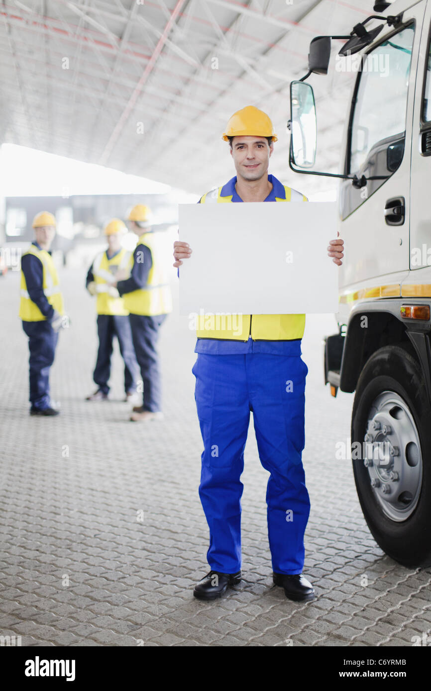 Worker holding blank card by truck Stock Photo - Alamy