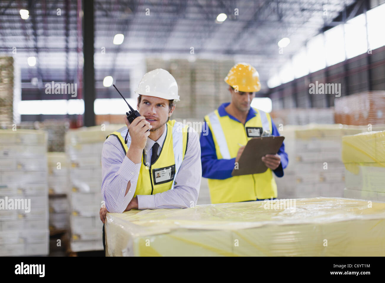 Worker using walkie talkie in warehouse Stock Photo - Alamy
