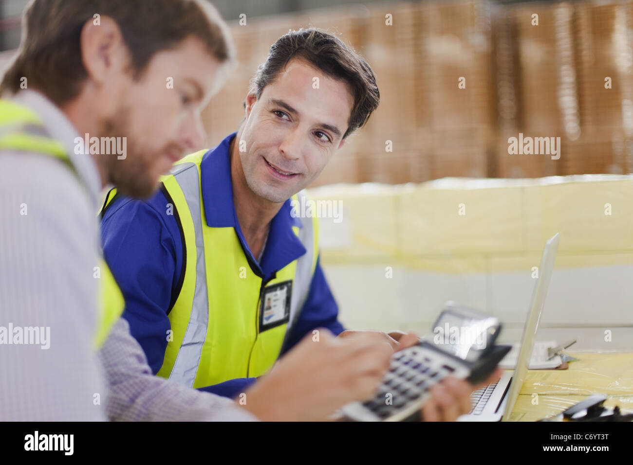 Workers using laptop in warehouse Stock Photo - Alamy
