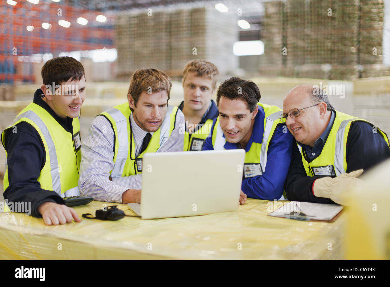 Workers using laptop in warehouse Stock Photo - Alamy