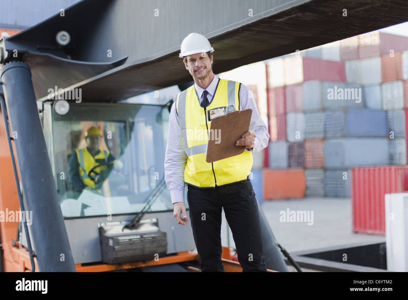Worker standing on machinery on site Stock Photo - Alamy