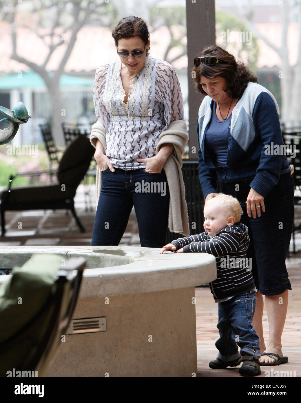 Minnie Driver and Henry Driver throwing coins into a wishing well at ...