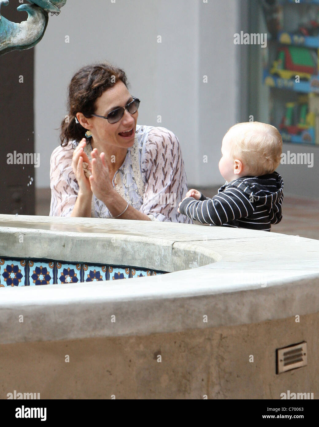 Minnie Driver and Henry Driver throwing coins into a wishing well at ...