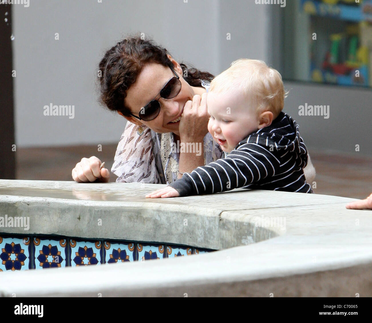 Minnie Driver and Henry Driver throwing coins into a wishing well at ...