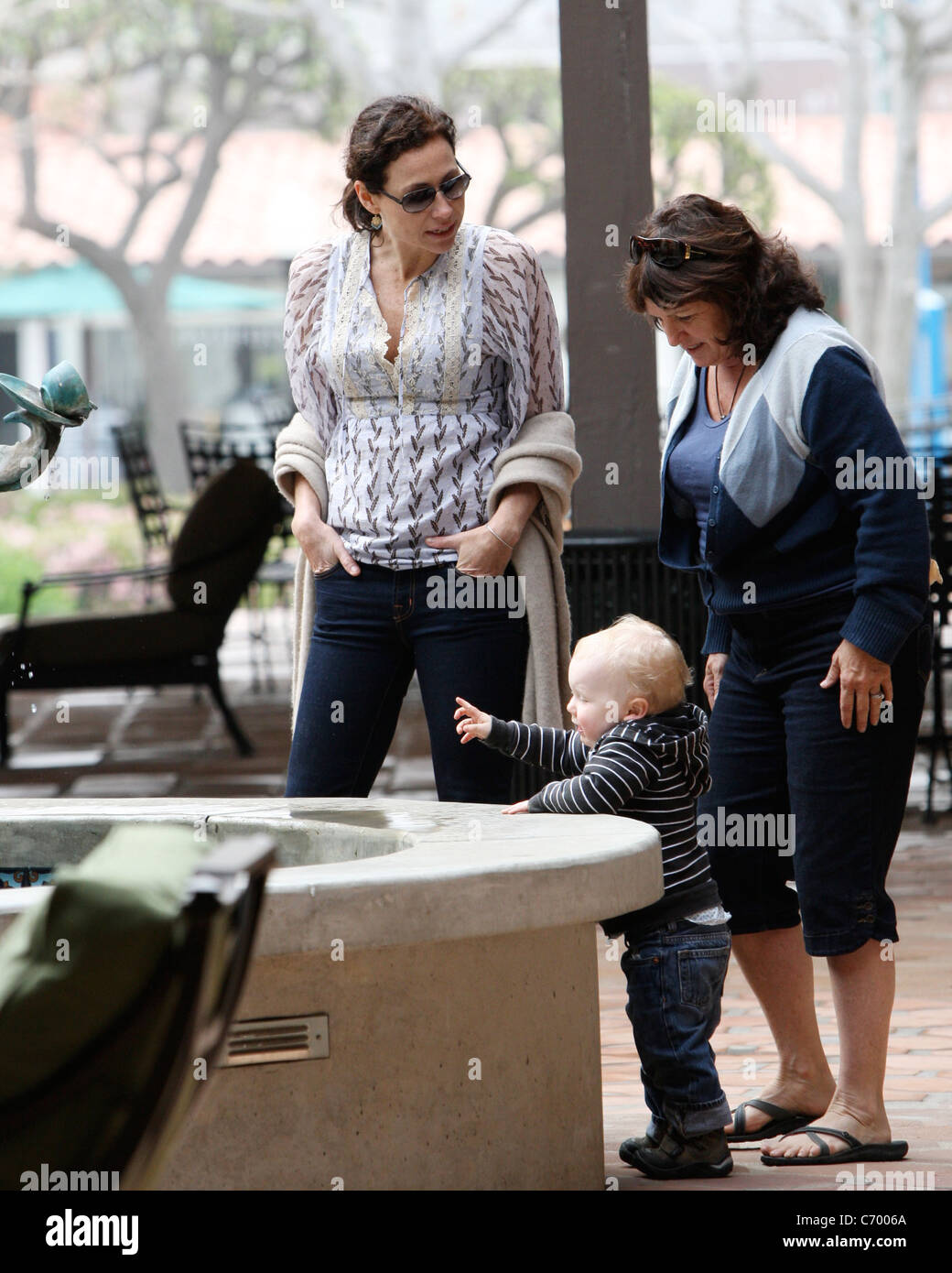 Minnie Driver and Henry Driver throwing coins into a wishing well at ...