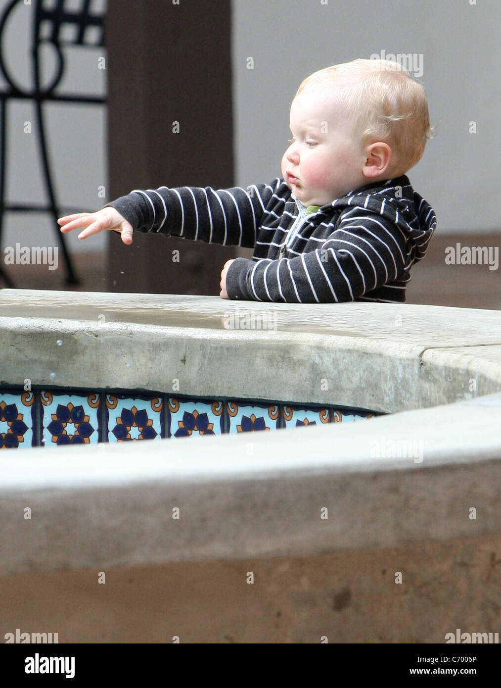 Minnie Driver and Henry Driver throwing coins into a wishing well at ...