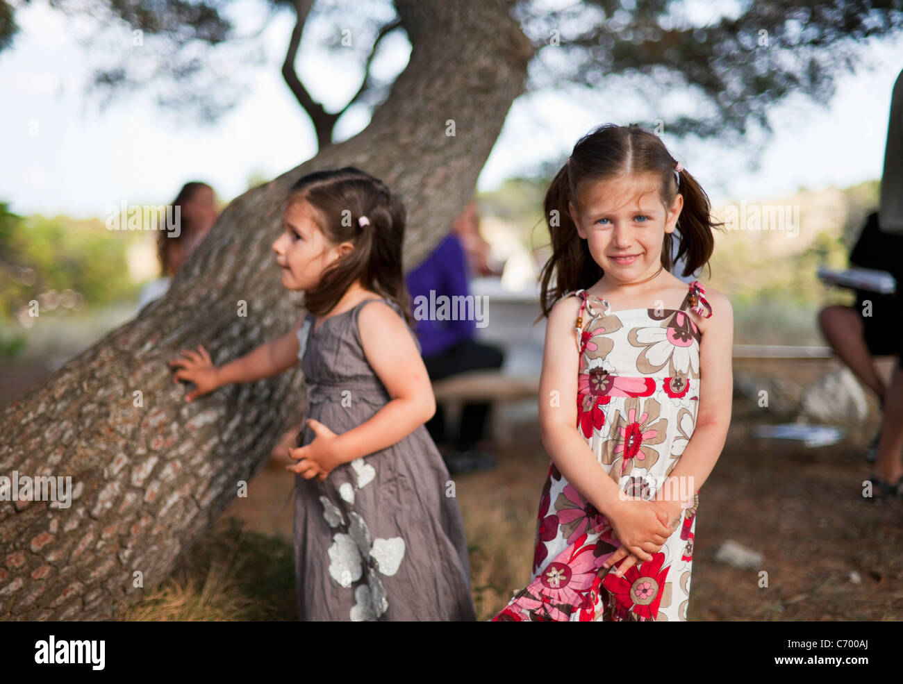 Girls playing by tree outdoors Stock Photo - Alamy