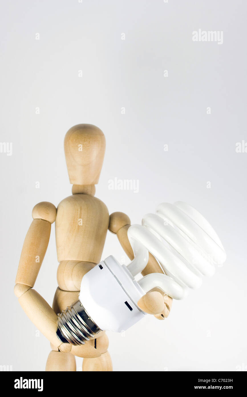 A wooden model grasping a compact fluorescent light bulb. Great for ...