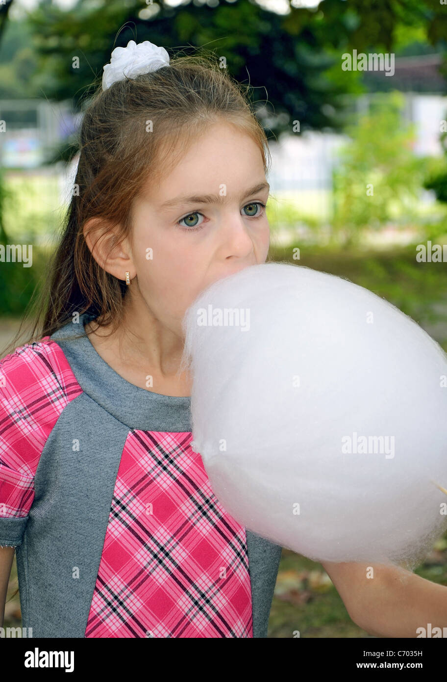 a girl eating sweet cotton wool Stock Photo - Alamy